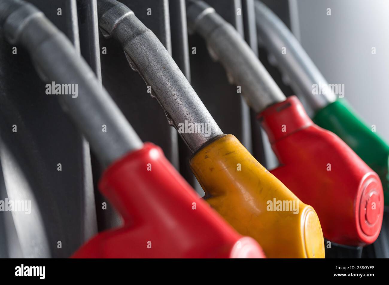 Colorful fuel pump nozzles at a modern gas station. Red, yellow, and ...