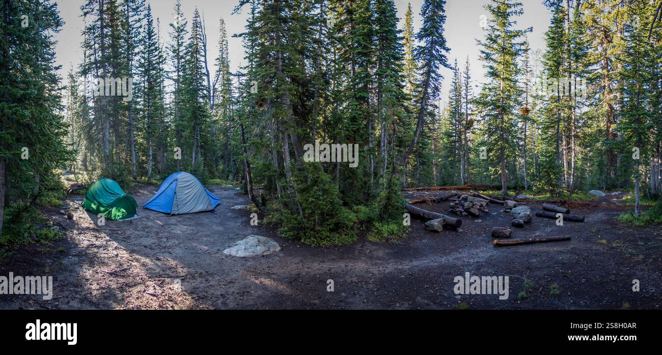 A campground with a fire pit and two tents Stock Photo - Alamy
