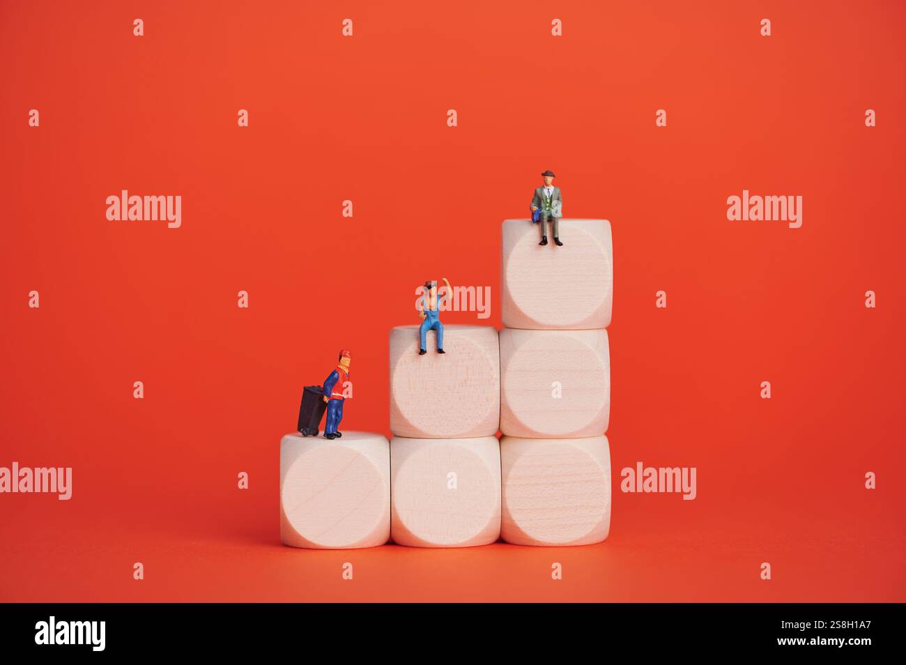 Small figures climb blocks to demonstrate income job hierarchy and ...