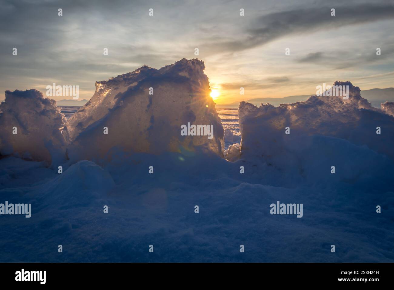 Low angle of ice drift on lake with sun peaking over ice edge Stock ...