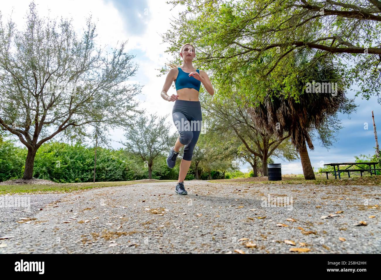 A radiant young woman in sleek, colorful workout gear exercises in a ...