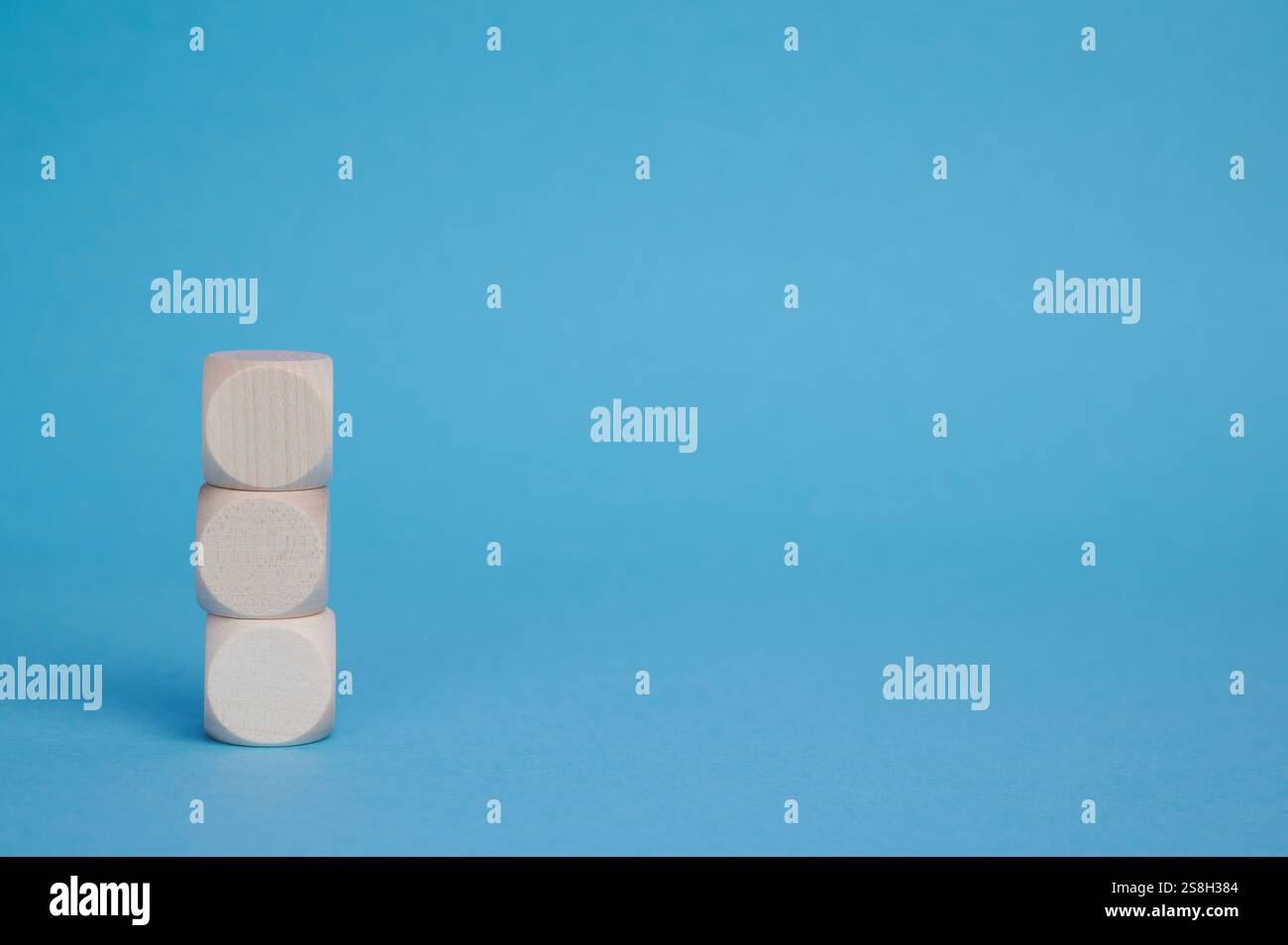 Three wooden blocks are stacked vertically against a blue background ...