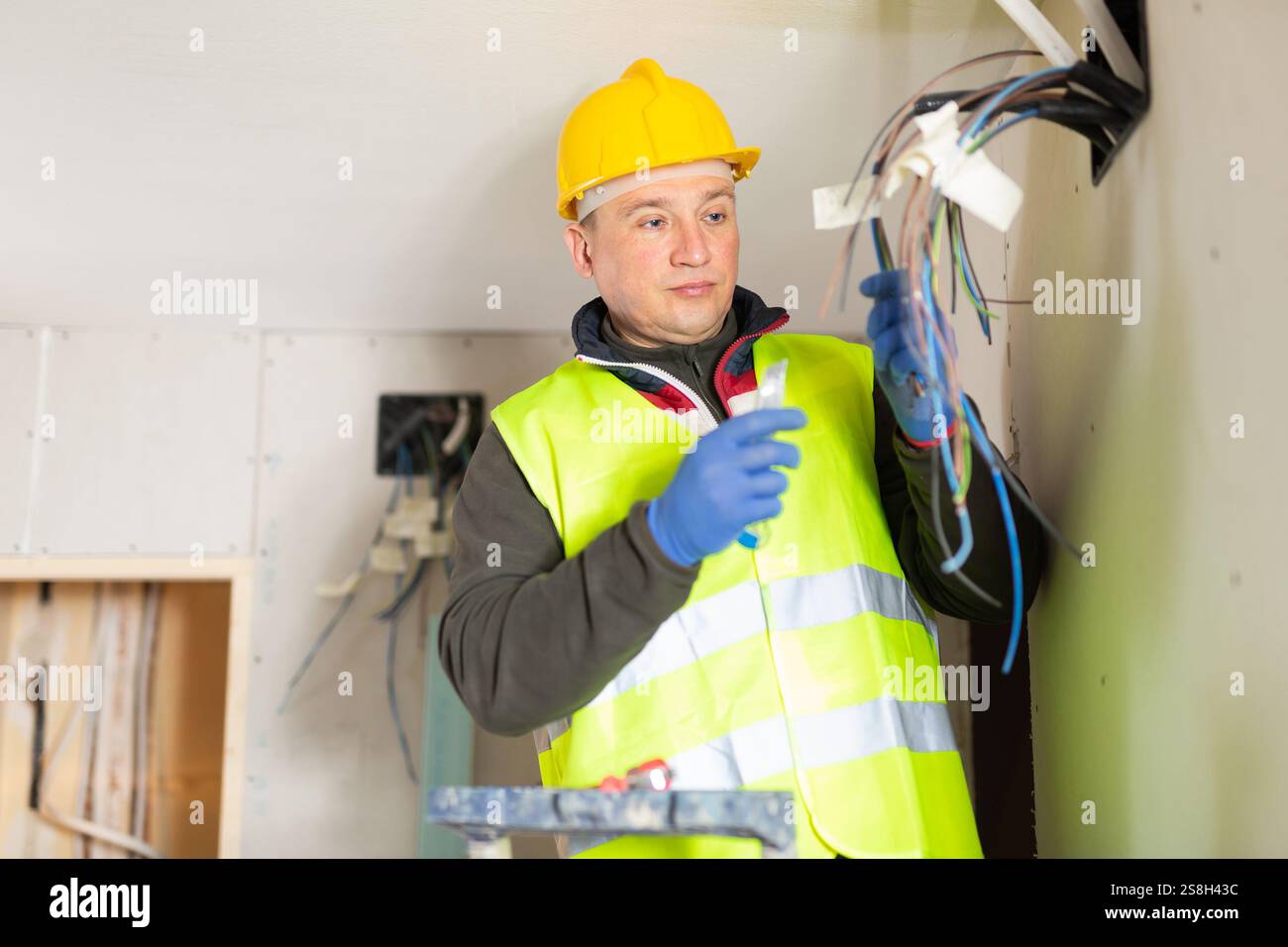 Electrician working with wires in apartment Stock Photo - Alamy