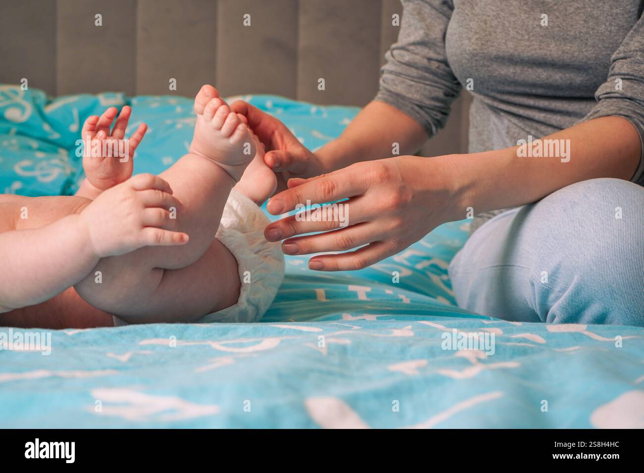 Baby foot between the fingers of her mother hand. Close up shot. Family ...