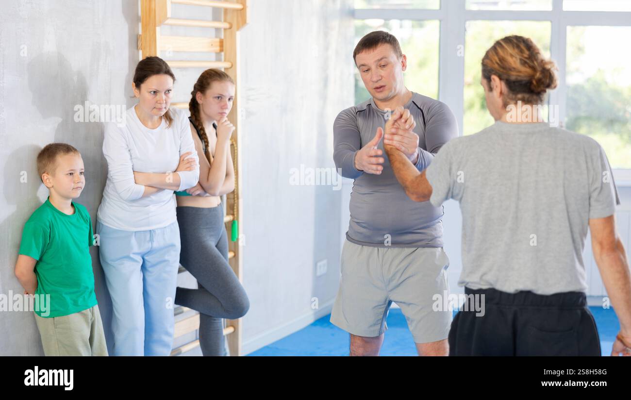 Trainer at self-defense training teaches students technique of grabbing ...