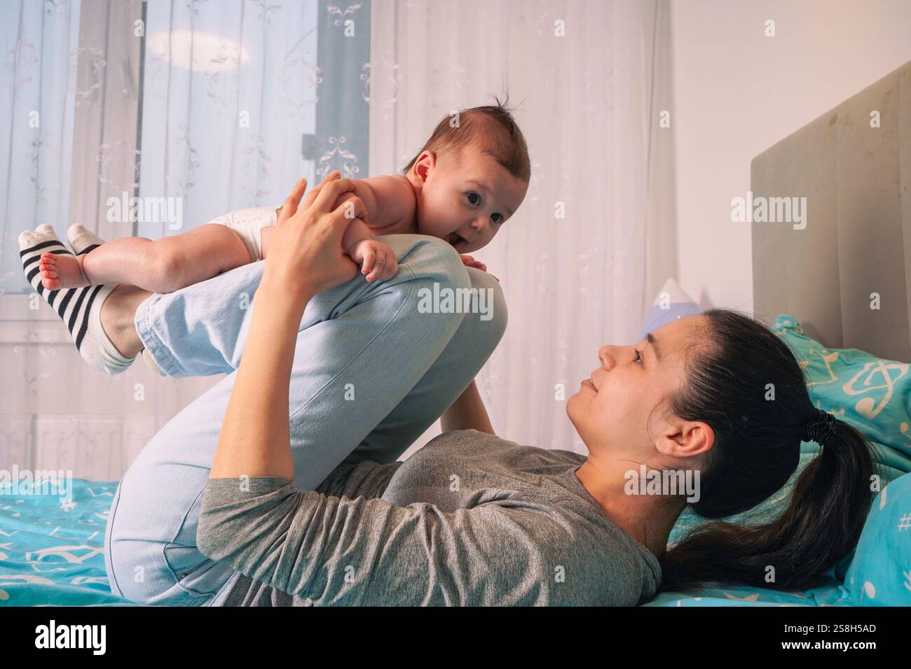 Wearing simple home attire, the mother leans slightly forward, her ...