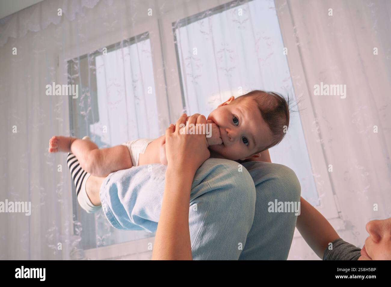 The mother s hair is casually tied back, strands of it falling Stock ...