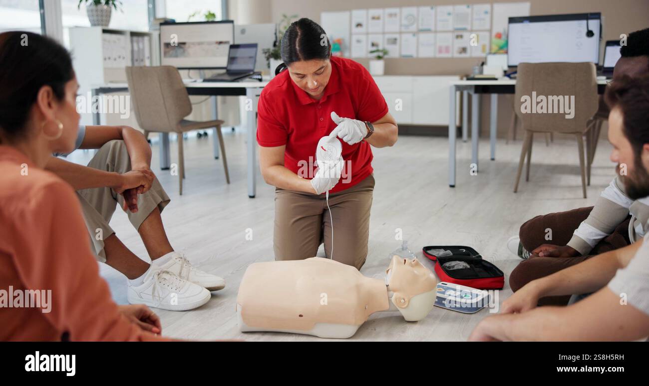 Mannequin, first aid and class with people and defibrillator for ...