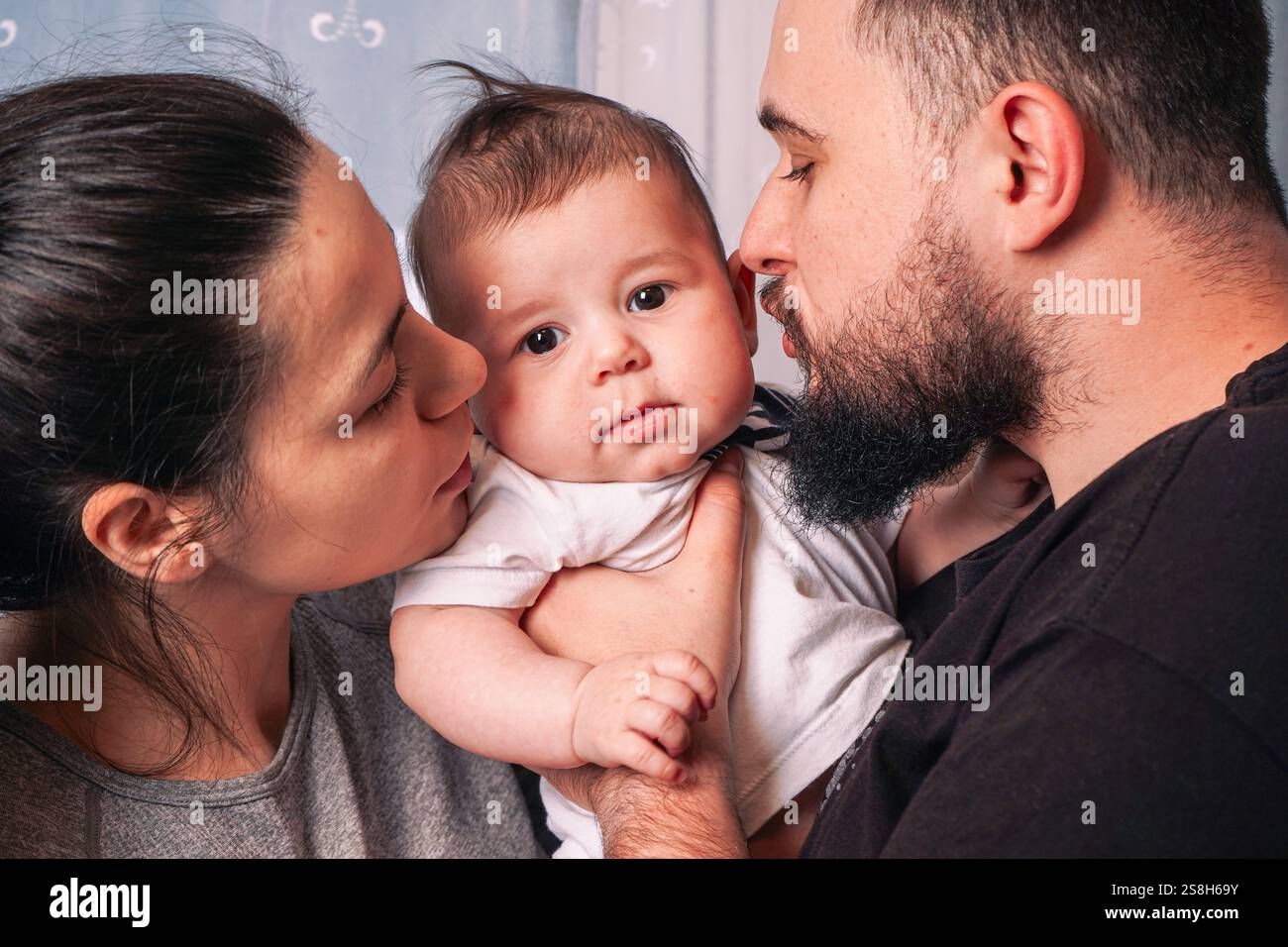 The baby, dressed in a simple diaper, giggles with delight as his ...