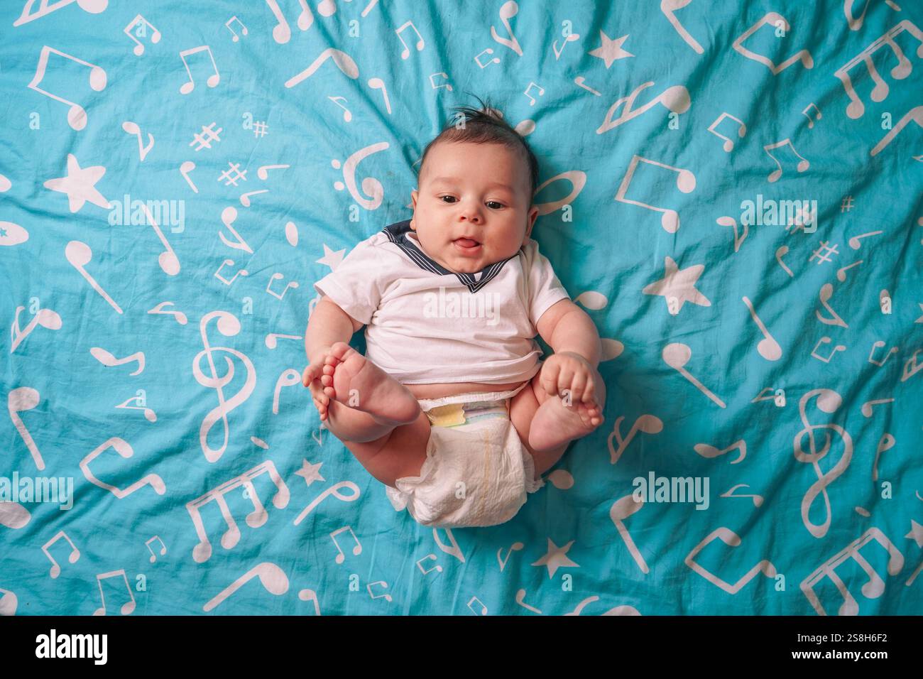 The baby turns his head slightly to one side, his innocent gaze ...