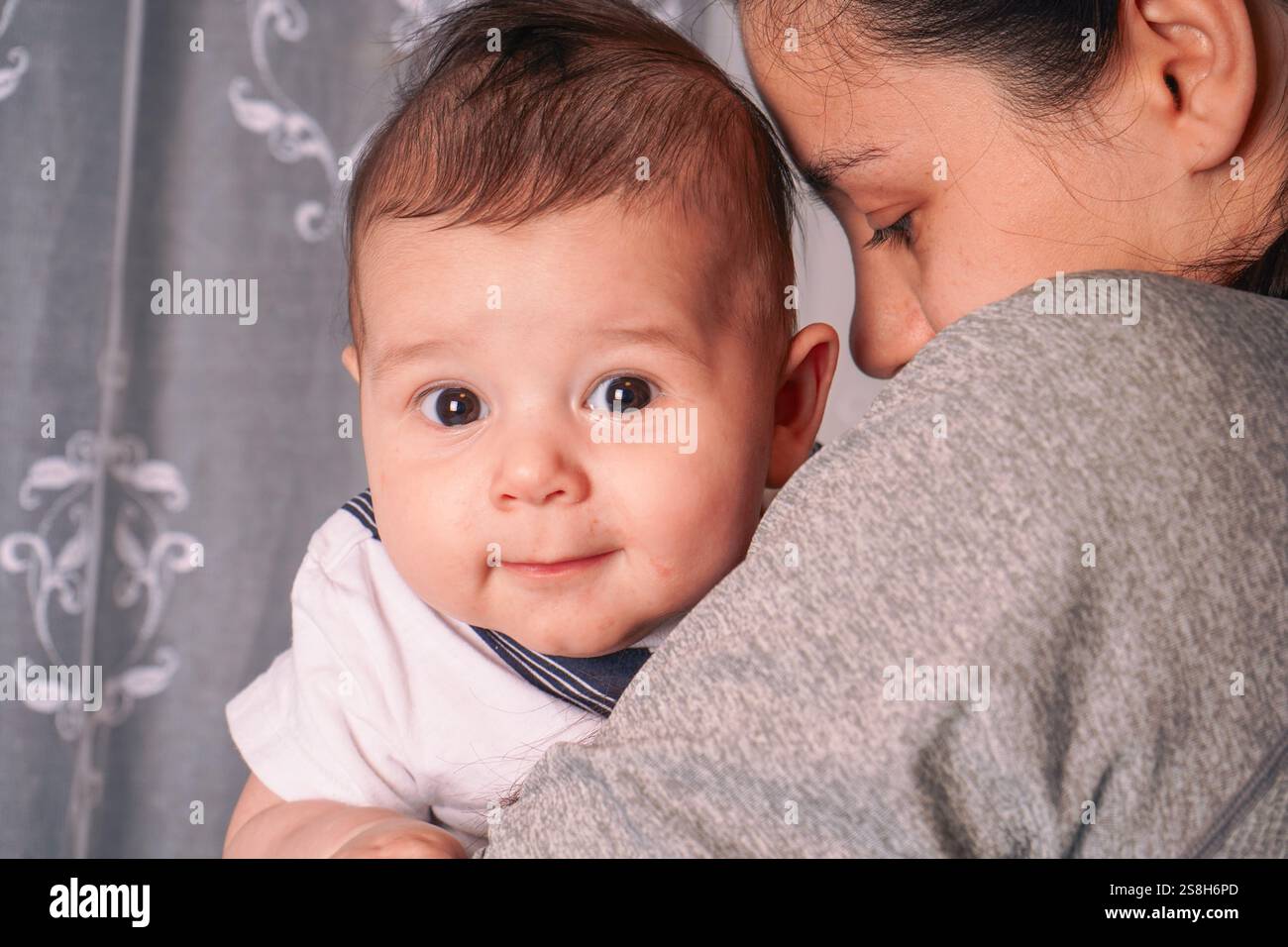 The mother s arms cradle her child securely, her tender smile Stock ...