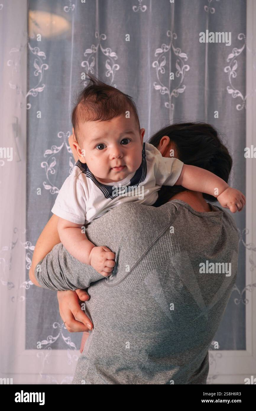 A young caring mother hugged her little son, holding him to her chest ...