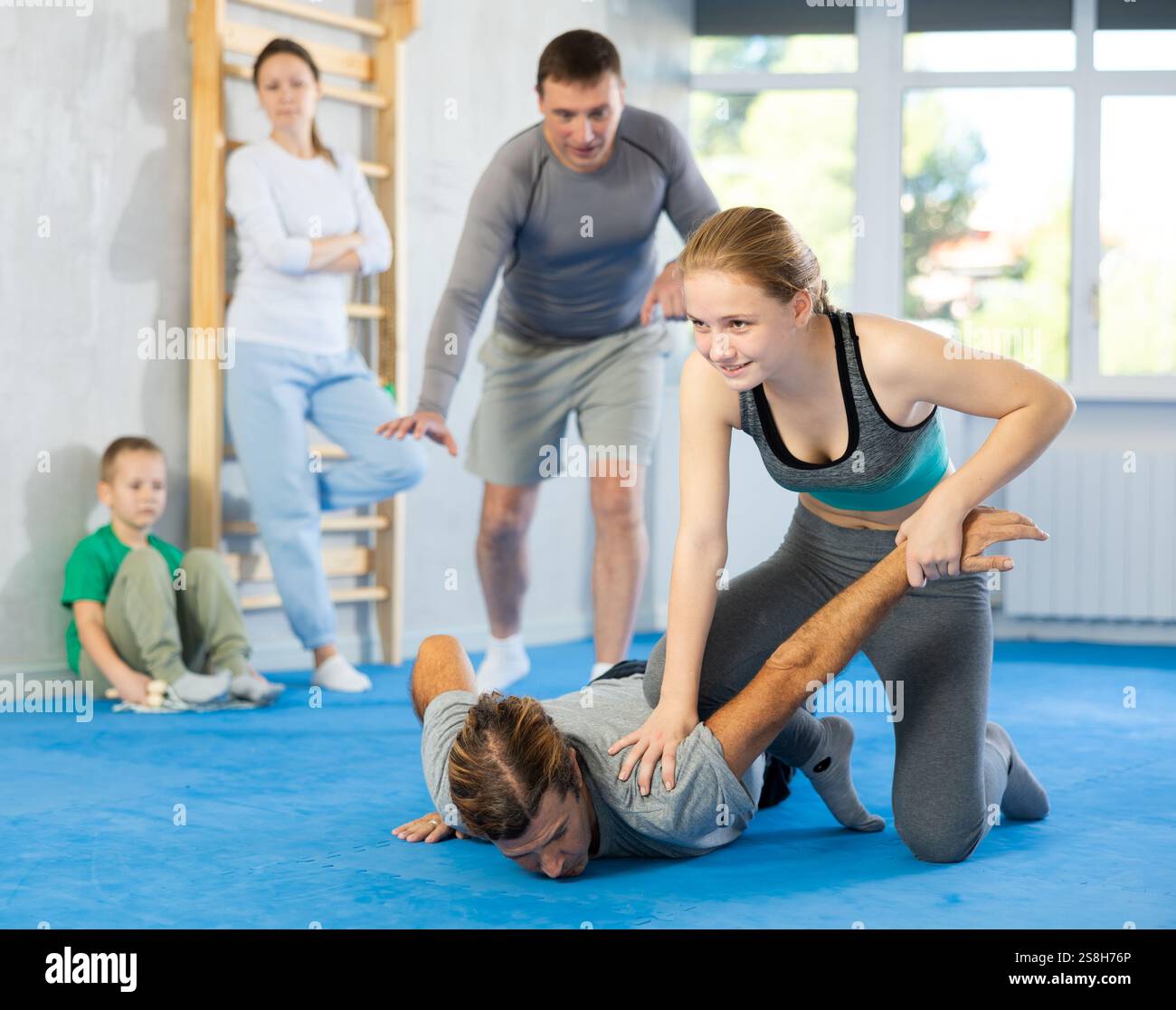 Teen girl in gym perform basic elements of krav maga self-defense ...