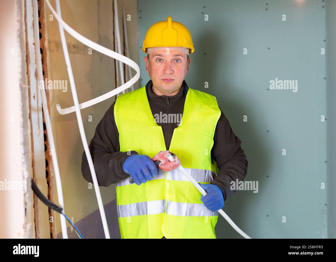 Repair man cutting cable duct for wires Stock Photo - Alamy