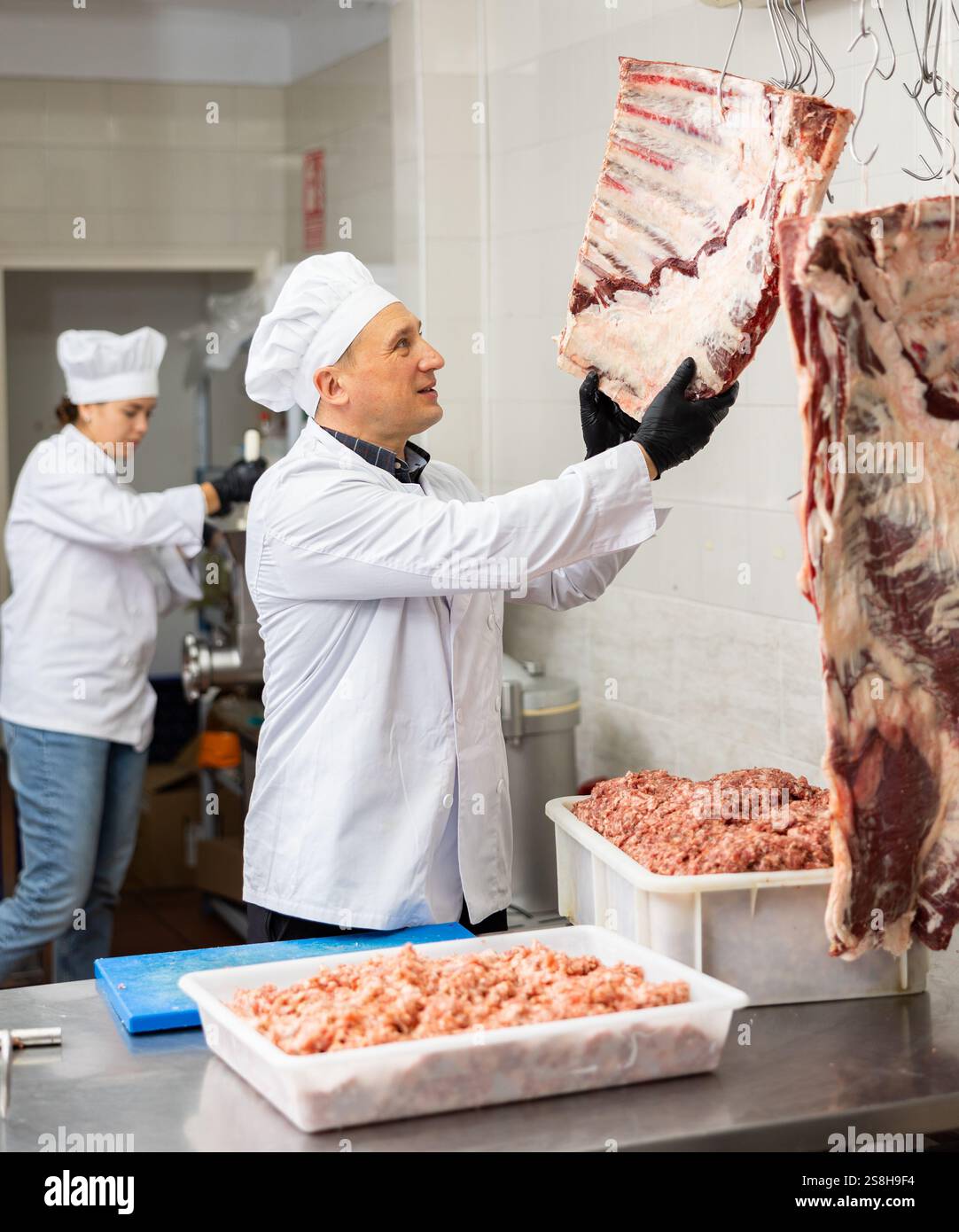 Adult male butcher holding beef ribs Stock Photo - Alamy