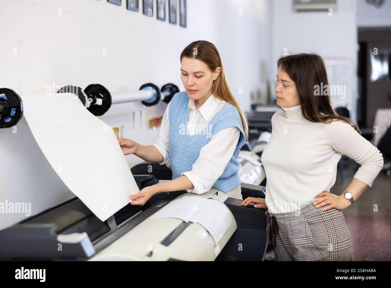 Printing office manager and employee loading printer with paper Stock ...