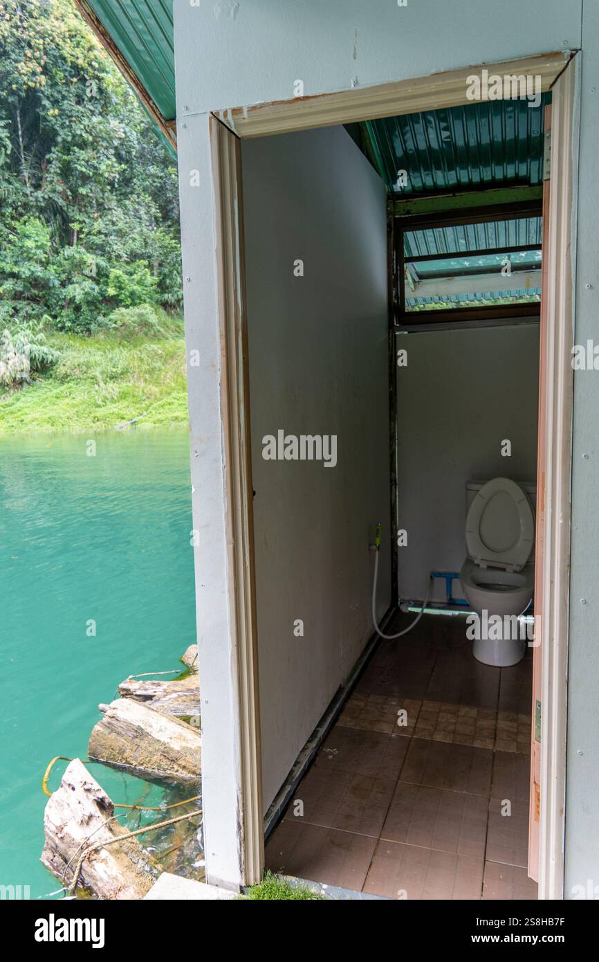 Unique restroom setup overlooking tranquil river in lush tropical ...