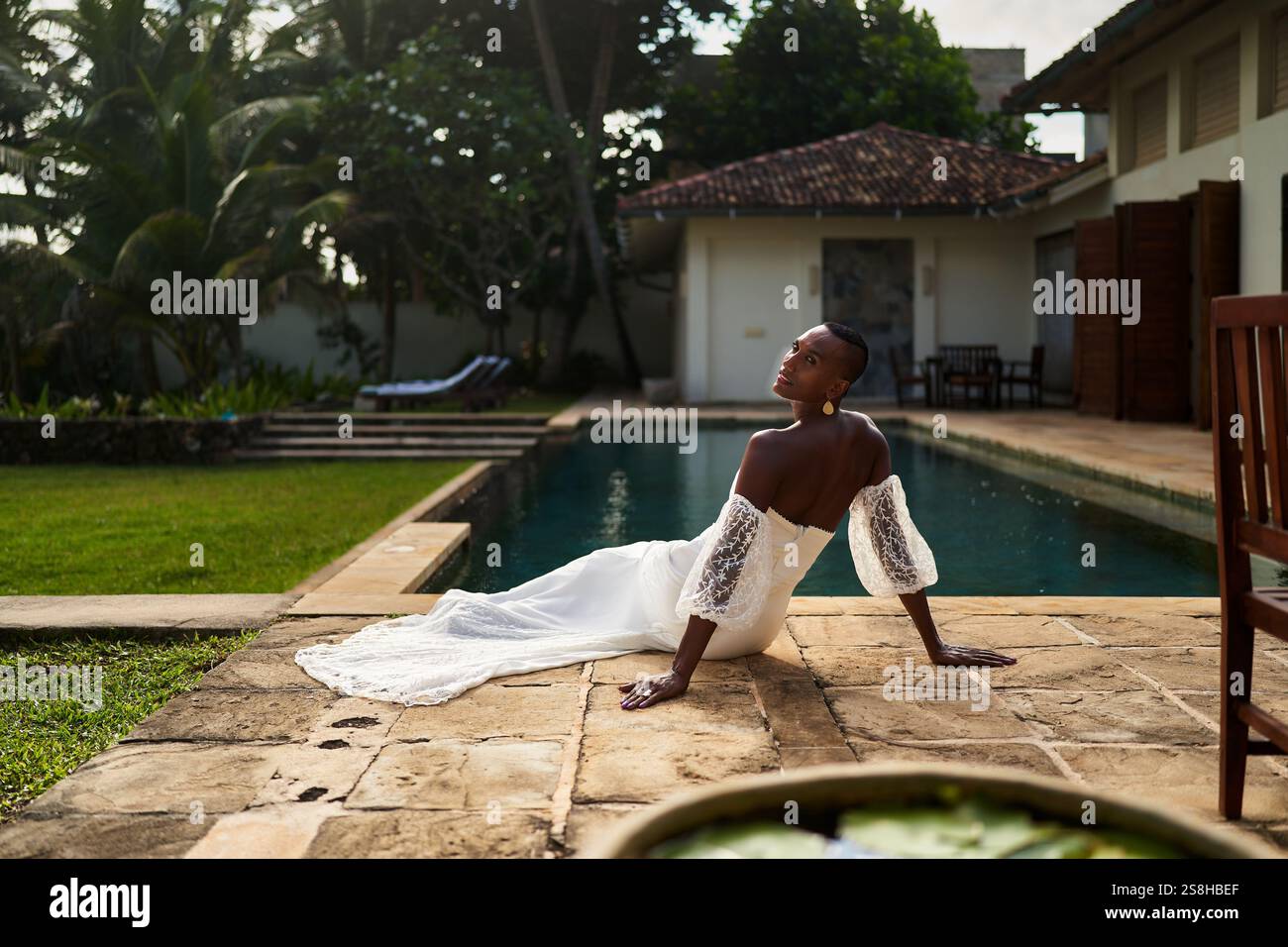 Ambiguous gender fluid black person in elegant white dress, villa ...