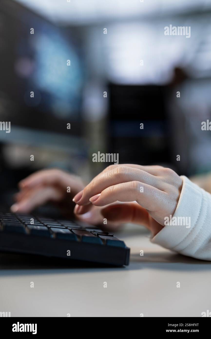 Engineer typing on keyboard in data center coordinating deployment of ...