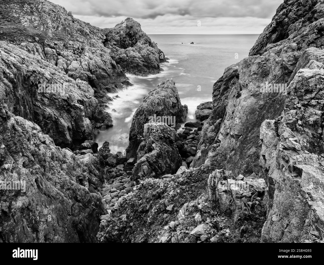 Rugged granite sea cliffs, with blurred long exposure sea, on the South ...