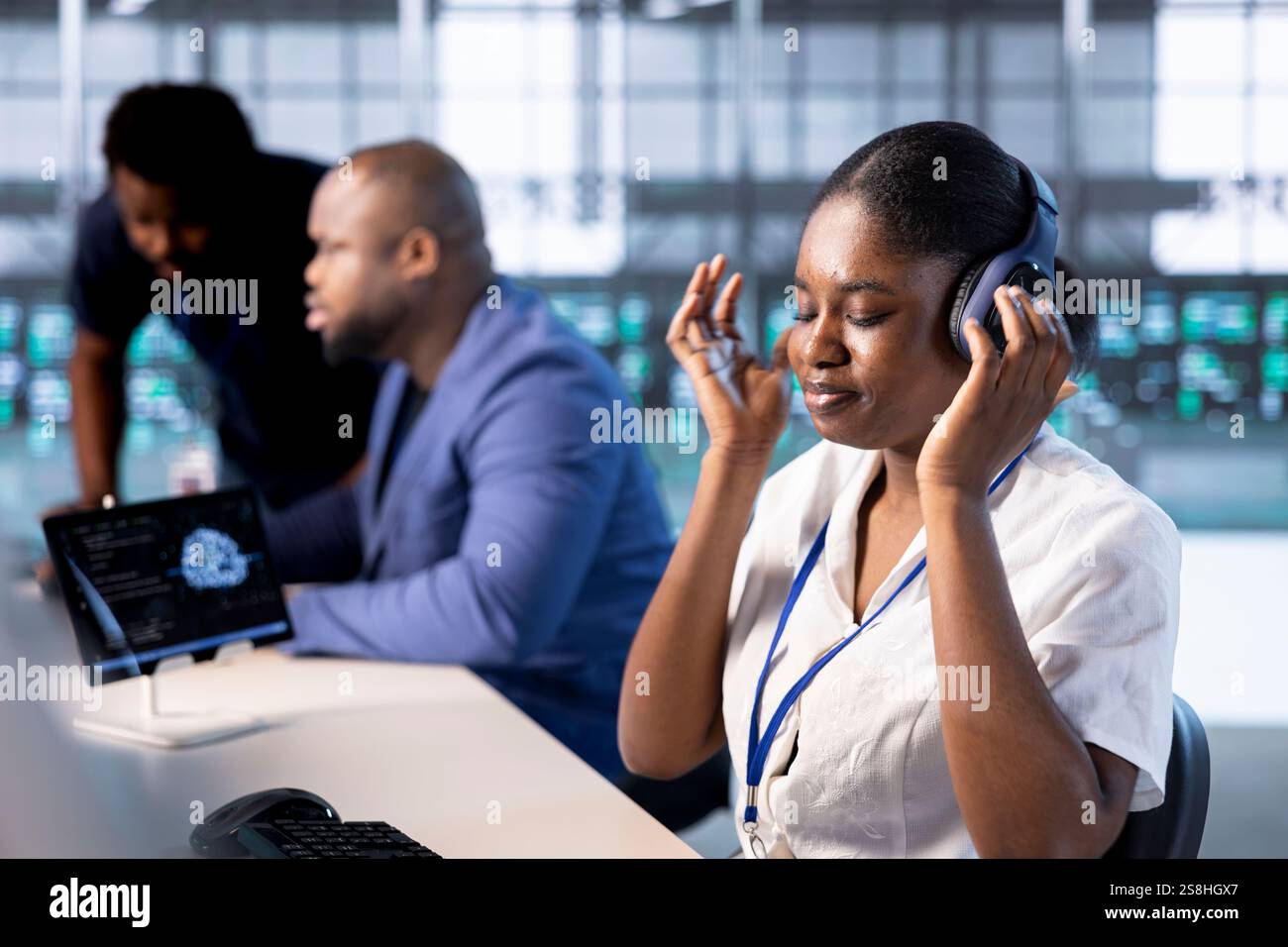 Engineer in data center listening songs while using system monitoring software on computers to ...