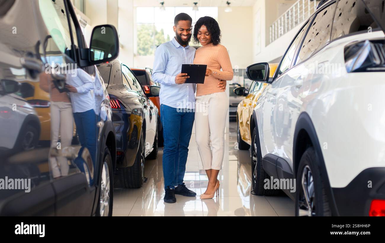 Young Black Couple Choosing Car In Modern Dealership Center, Checking ...
