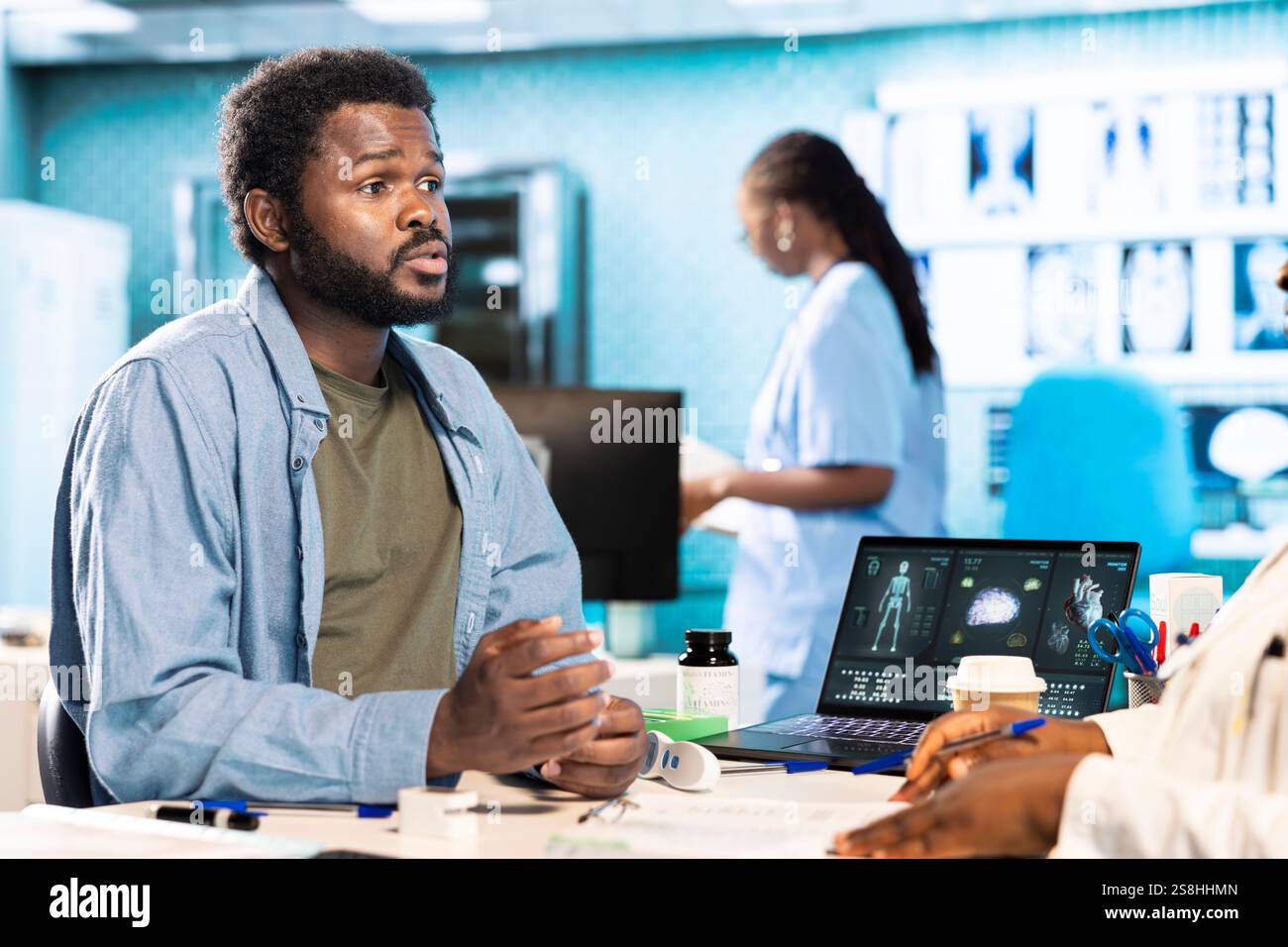 Black male patient bringing x ray test results to medic for scan ...