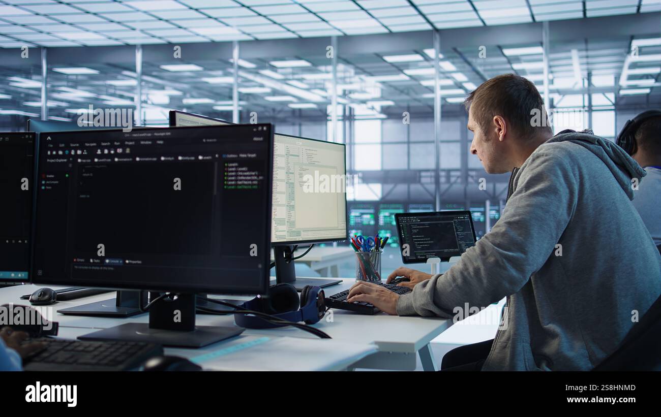 Technician arriving at work in high tech server room, analyzing data on ...