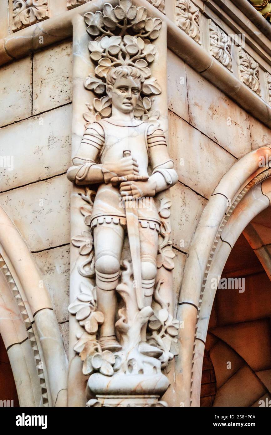 A statue of a knight holding a sword is carved into a stone pillar. The ...