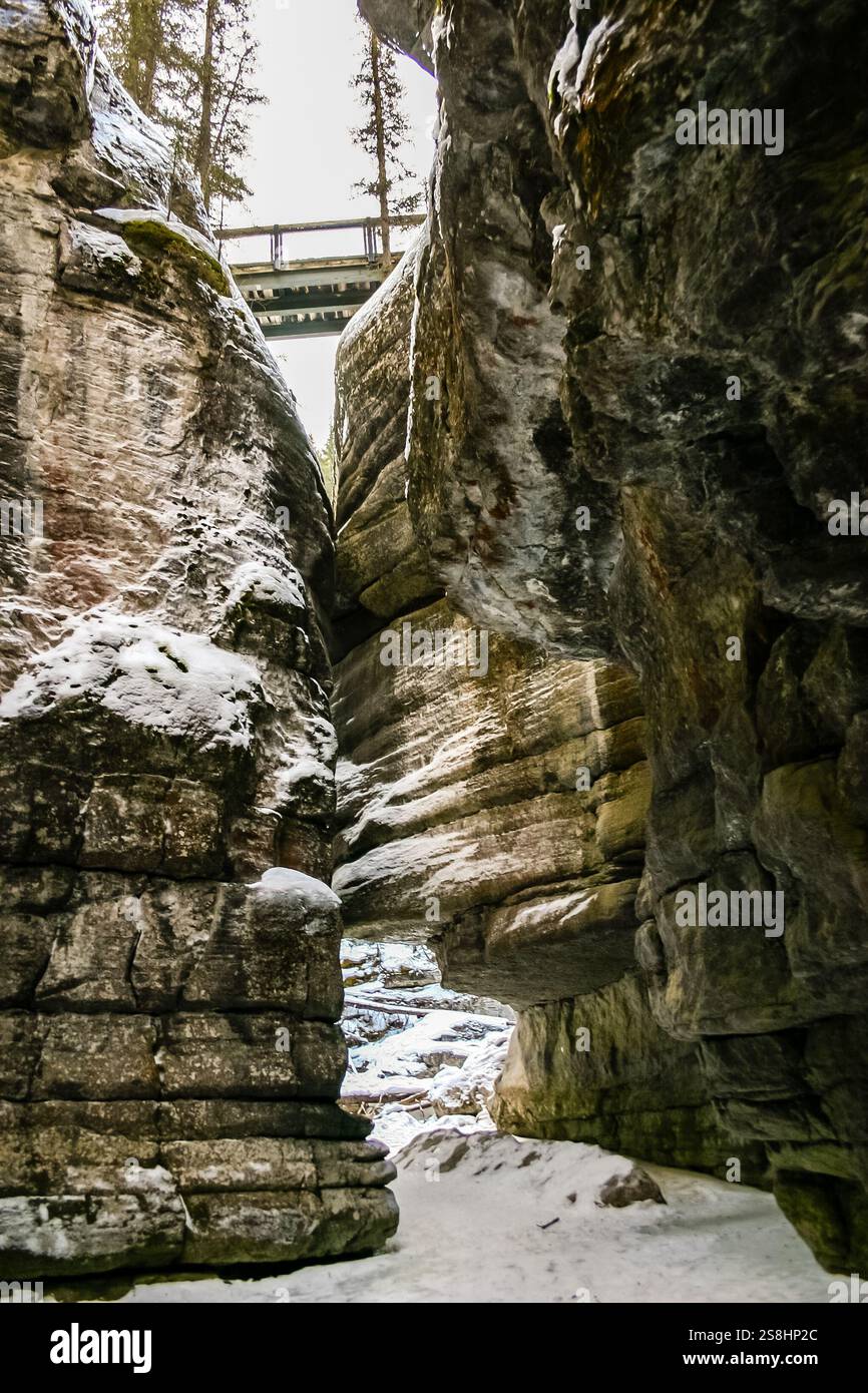 A narrow passage between two large rocks with snow on them. The passage ...