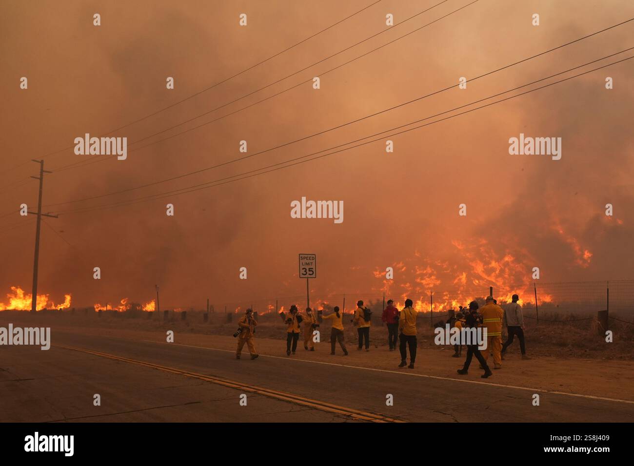 Firefighters monitor flames caused by the Hughes Fire along Castaic ...
