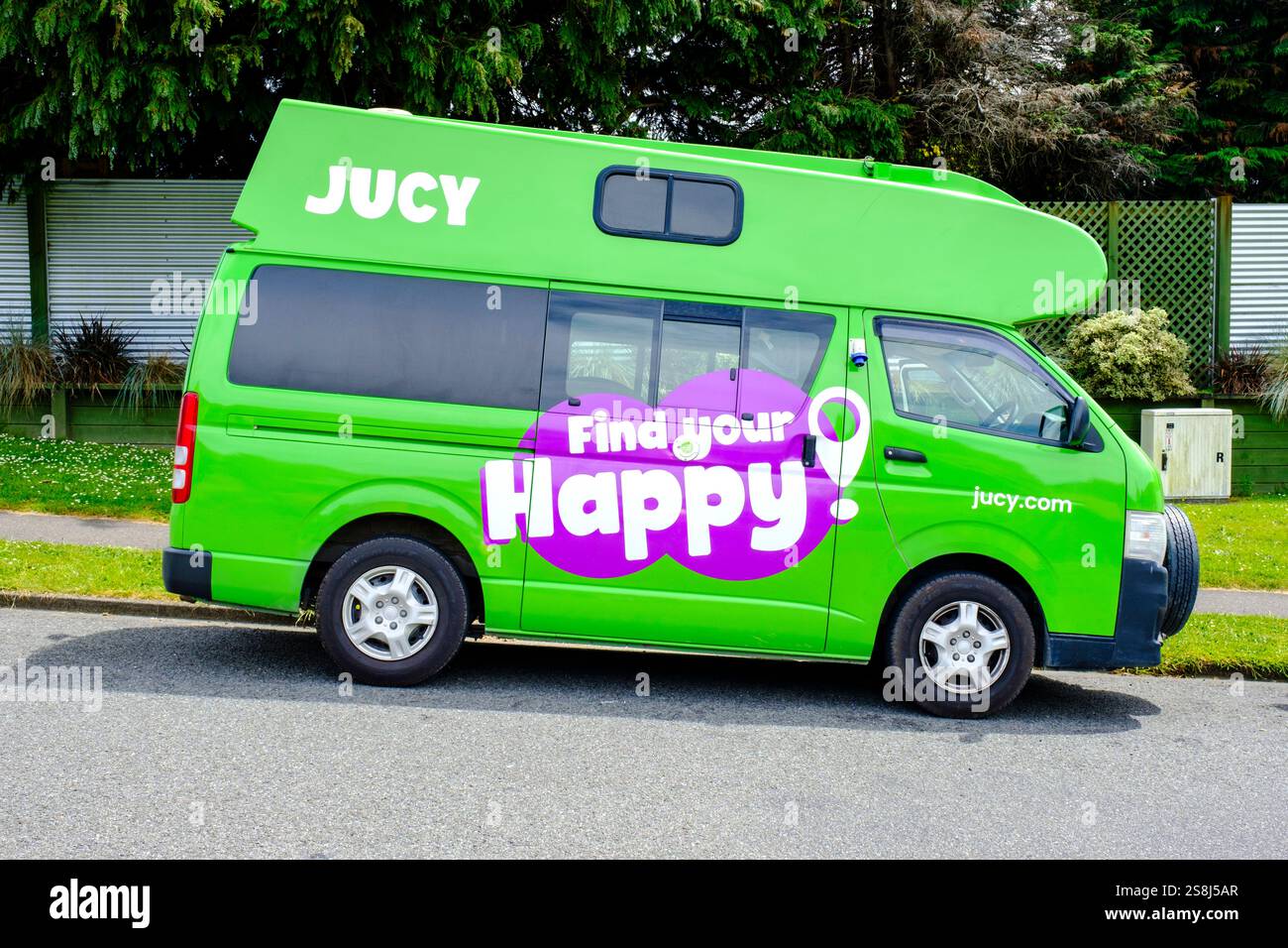 Side view of a parked green Jucy campervan used for independent road ...