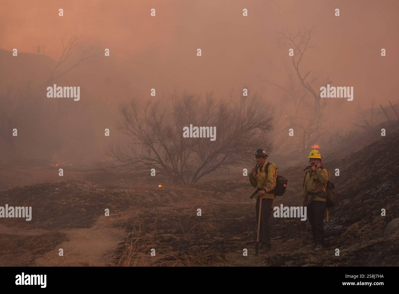 Firefighters monitor flames caused by the Hughes Fire is seen along ...