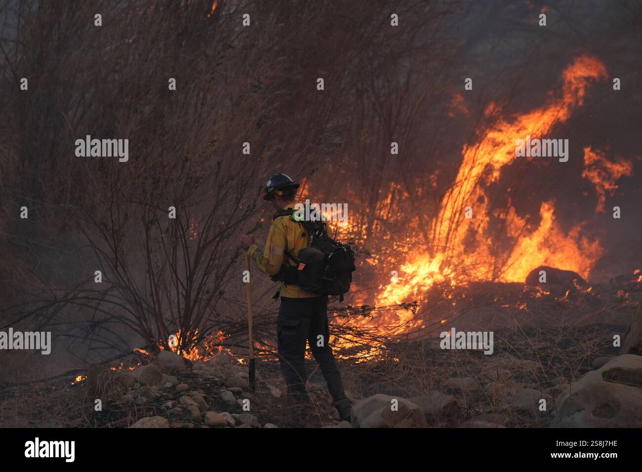 A firefighter monitors flames caused by the Hughes Fire is seen along ...