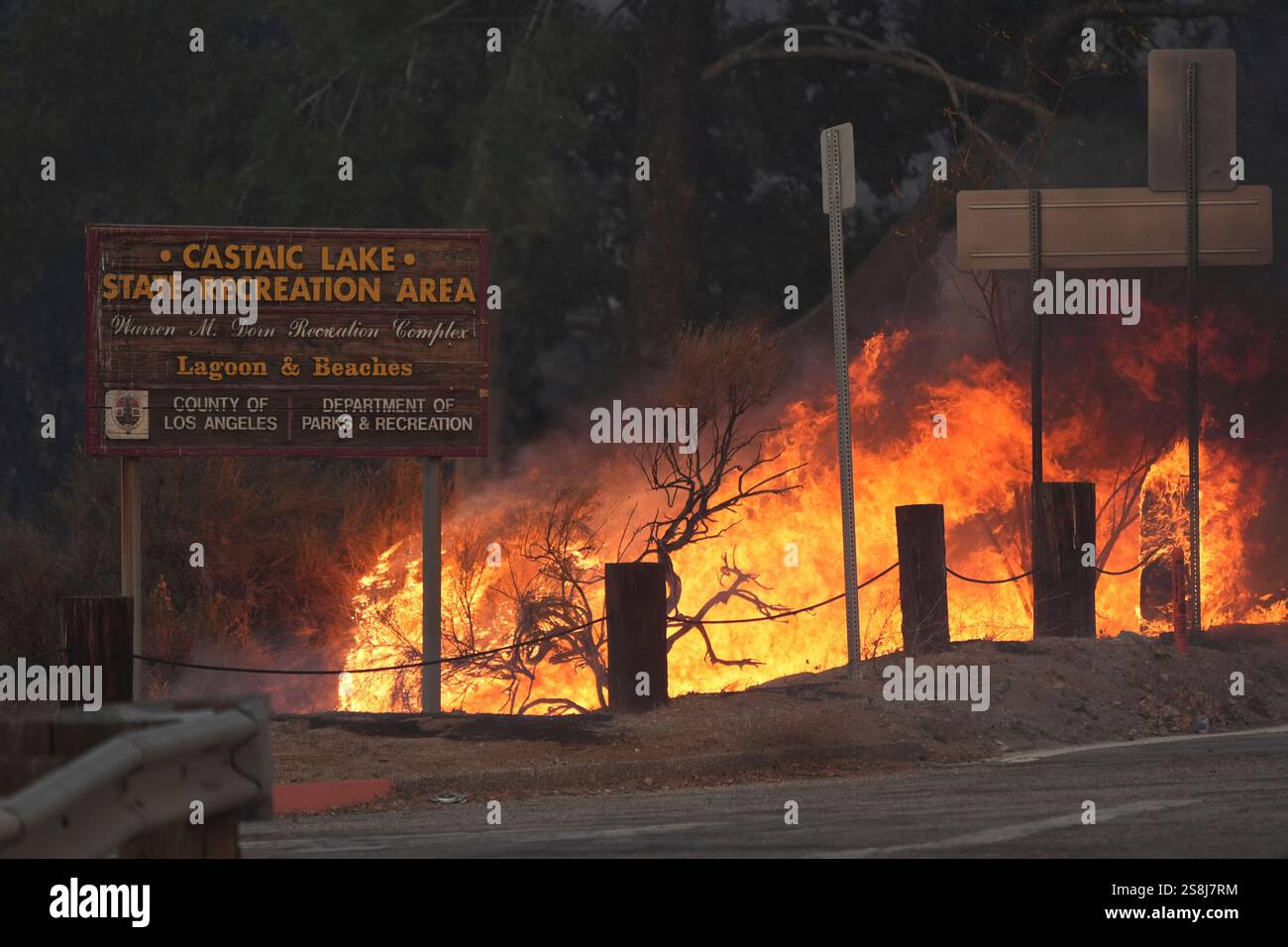 Flames caused by the Hughes Fire is seen along Castaic Lake in Castaic ...
