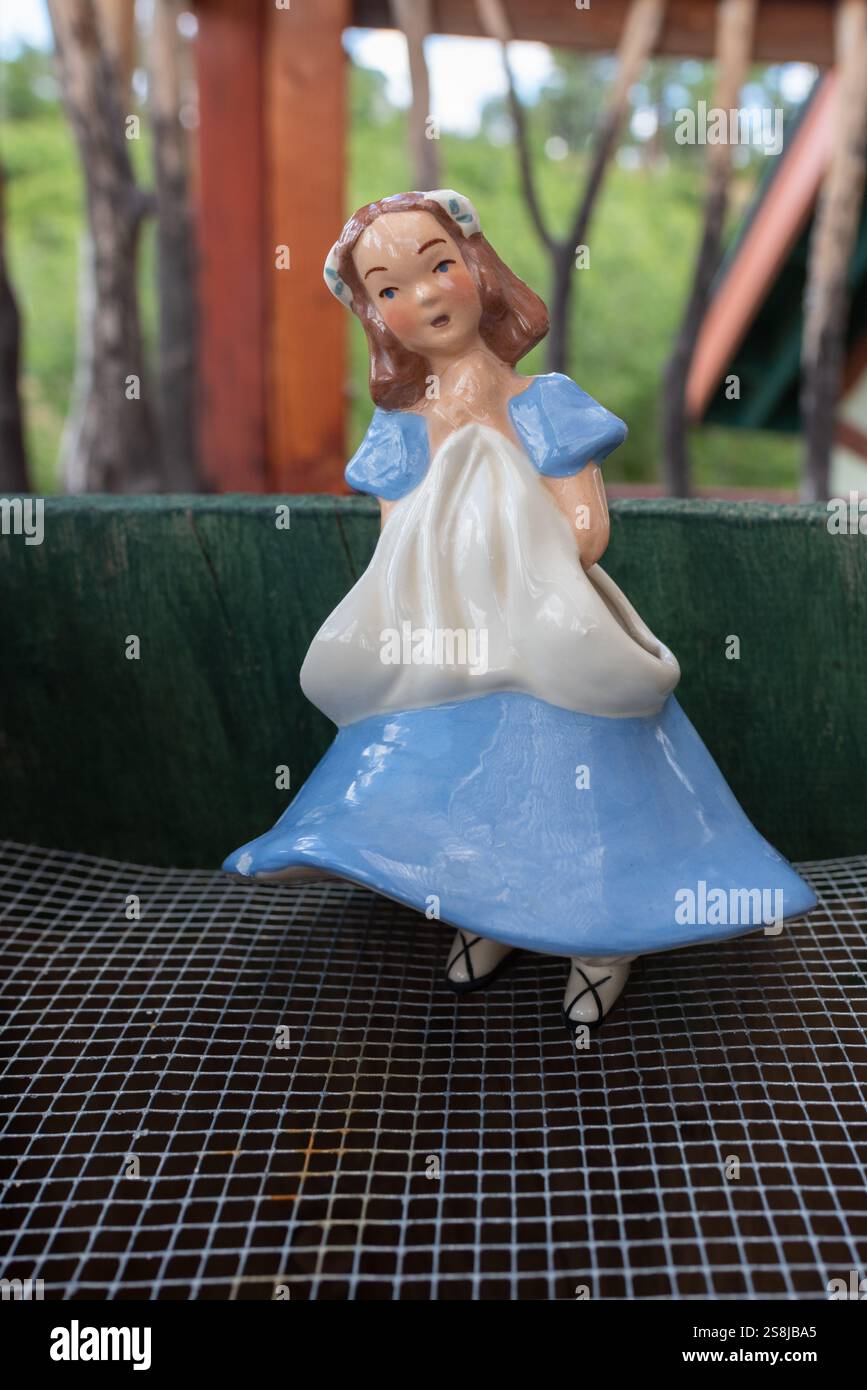 Vintage ceramic flower vase of a young woman holding up apron creating ...