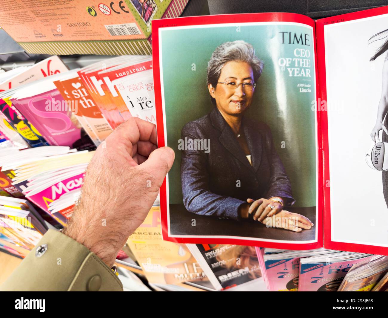 Paris, France - Dec 28, 2024: A person flipping through Time magazine ...