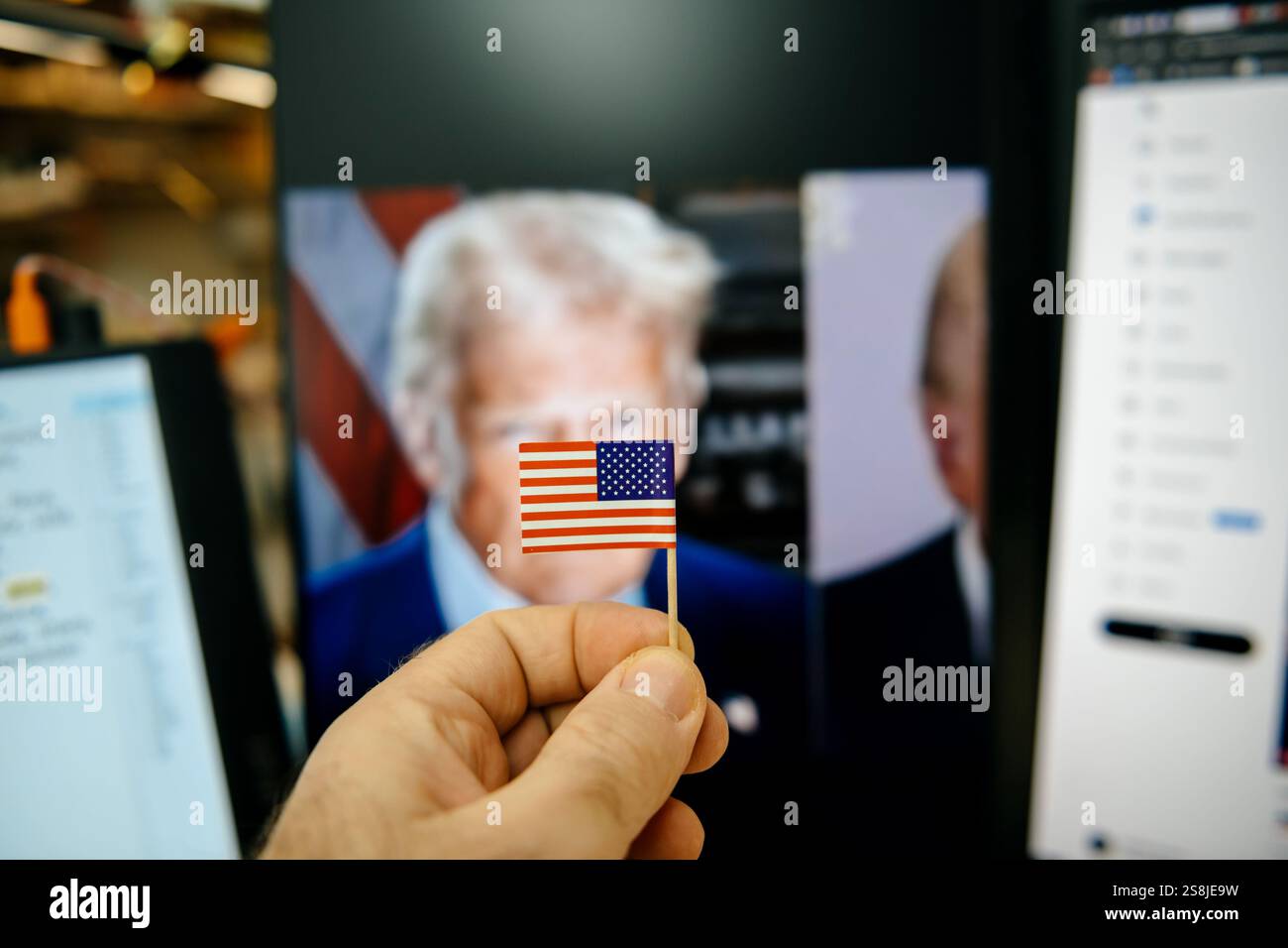 Paris, France - Jan 20, 2025: A hand holding a miniature American flag ...