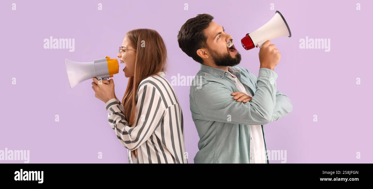 Angry young couple shouting into megaphones on lilac background Stock ...
