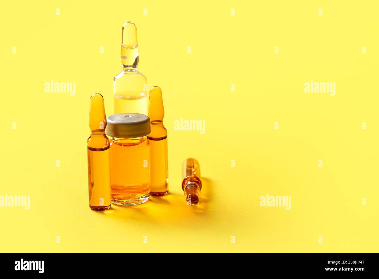 Medical ampules and bottle with medicines on yellow background Stock ...
