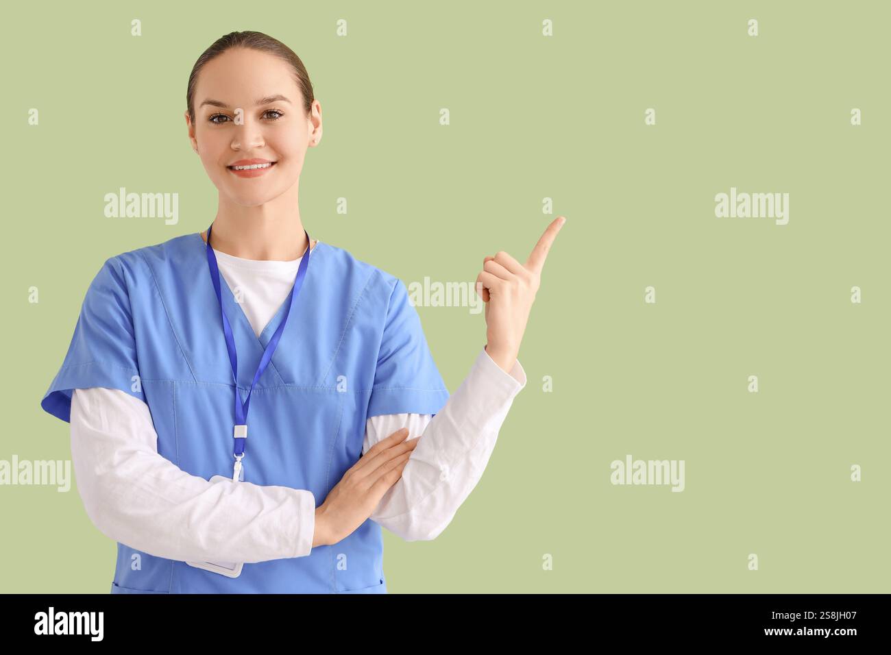 Female medical intern pointing at something on green background Stock ...