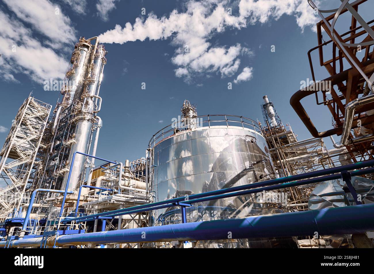 The distillation column at a modern chemical plant under a clear blue ...