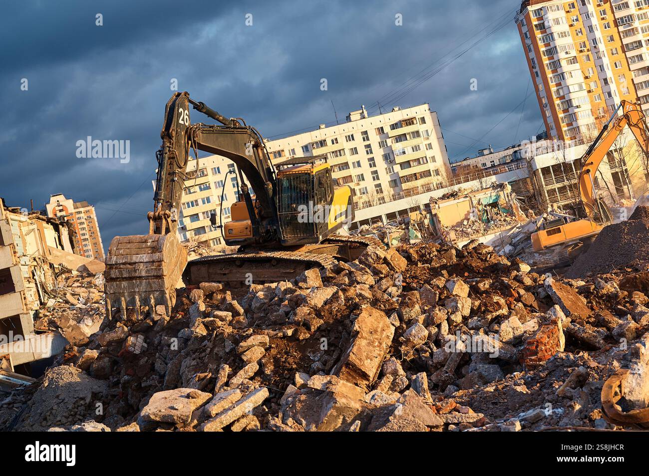 Building excavator with bucket stands on concrete waste Stock Photo - Alamy