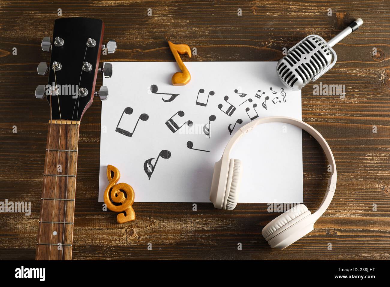 Paper sheet with music notes, headphones, microphone and guitar on ...