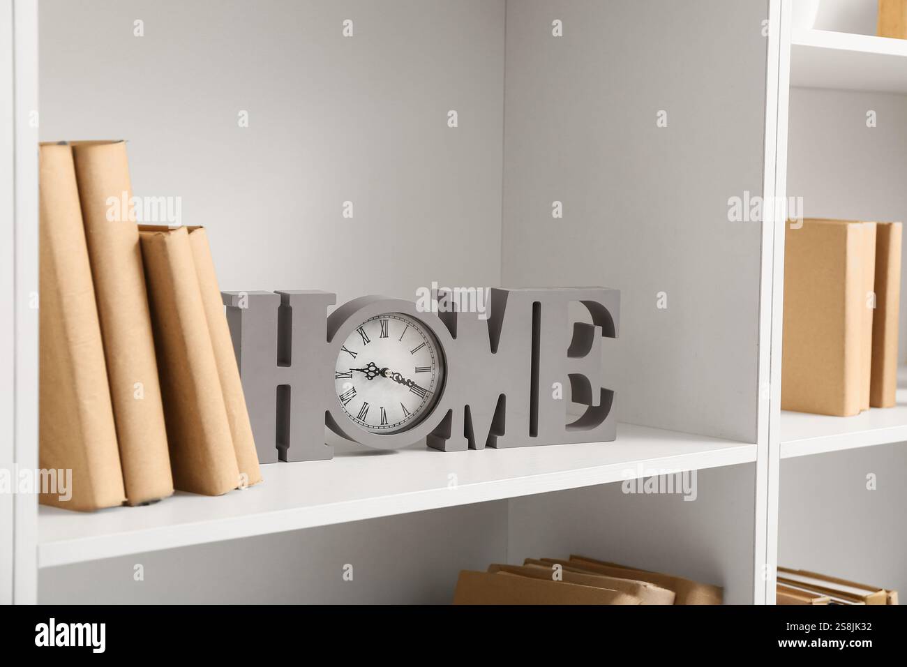 Shelves with books and stylish clock, closeup Stock Photo - Alamy