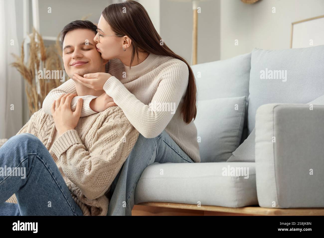 Cute young couple in warm sweaters hugging at home Stock Photo - Alamy