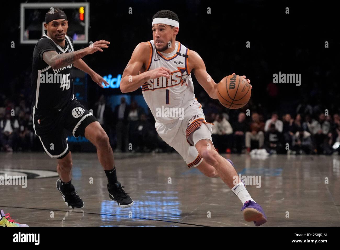 Phoenix Suns' Devin Booker (1) drives past Brooklyn Nets' Keon Johnson ...
