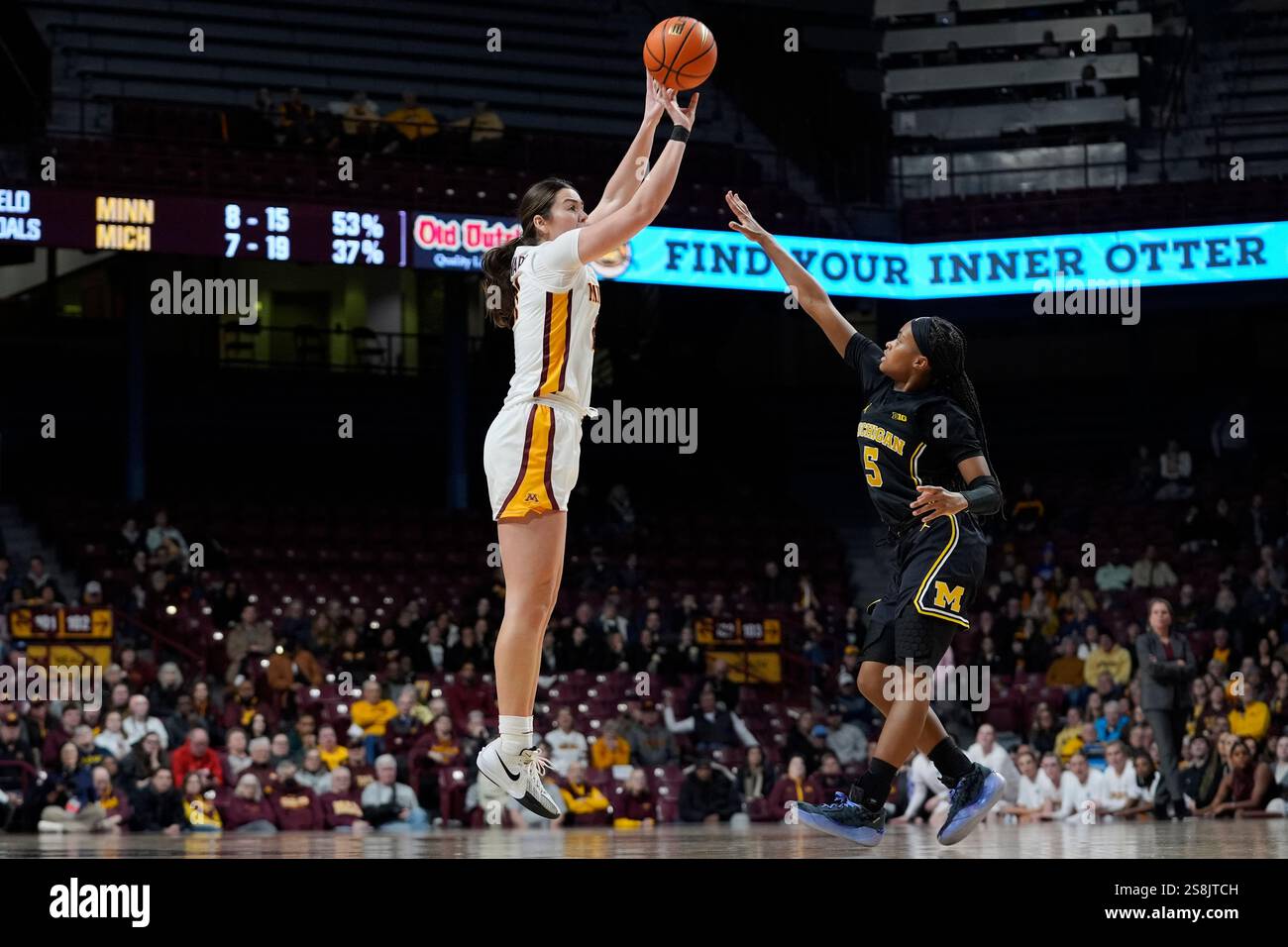 Minnesota forward Annika Stewart (21) shoots over Michigan guard Brooke ...