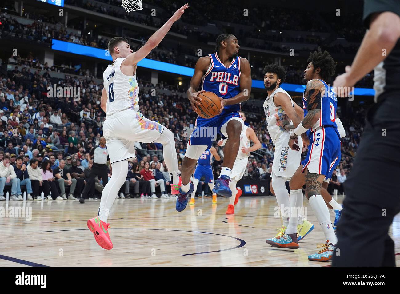 Philadelphia 76ers guard Tyrese Maxey (0) drives between Denver Nuggets ...