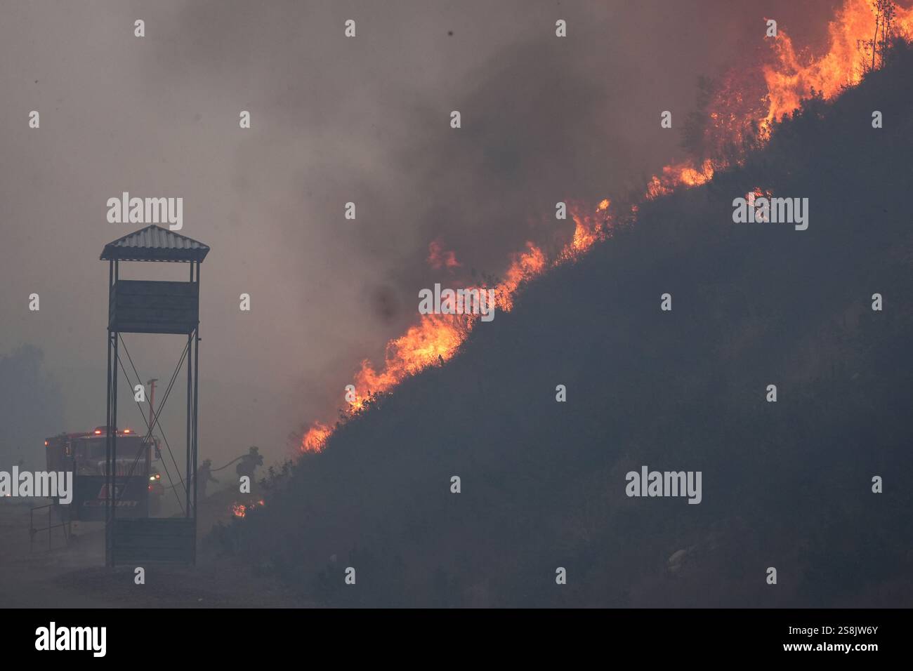 Firefighters monitor flames caused by the Hughes Fire is seen in ...